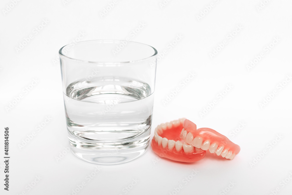 Full removable plastic denture of the jaws. Set of dentures on a white ...