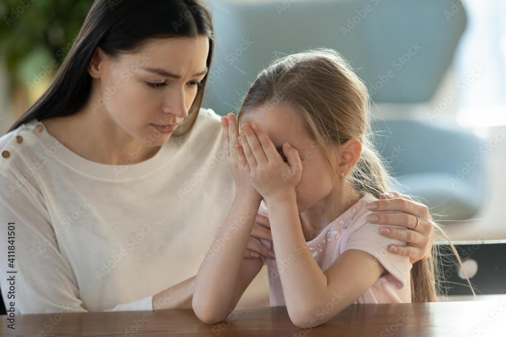 Loving young Caucasian mother hug comfort upset sad small 7s daughter ...