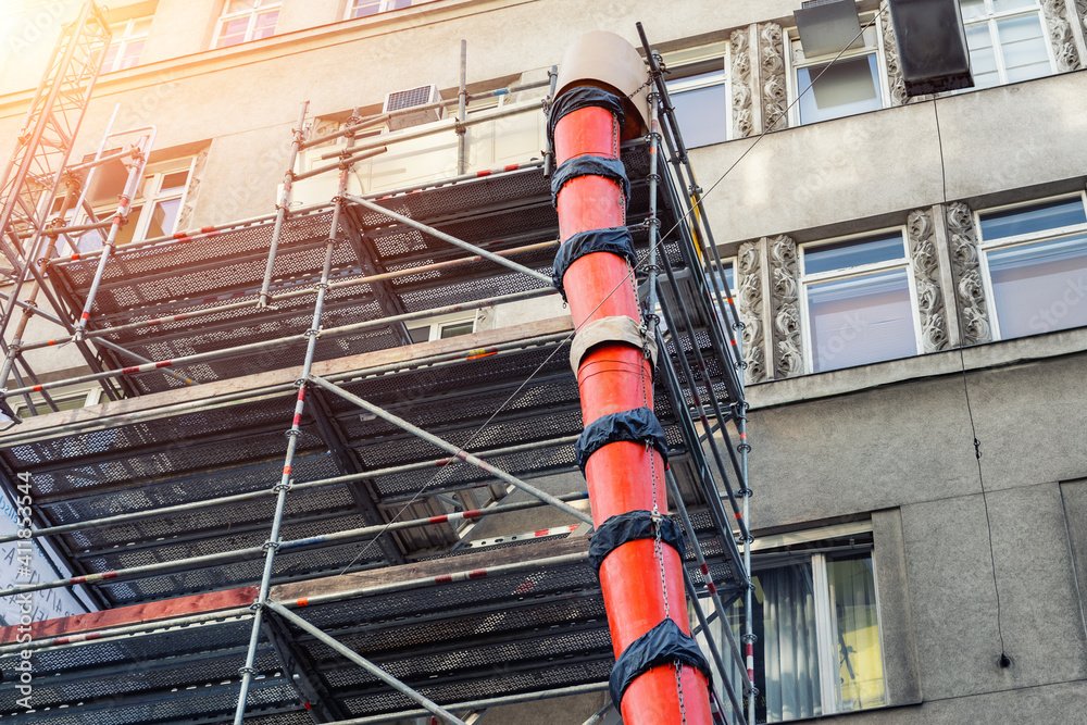 Póster Scaffolding with big red plastic slide chute for rubble debris ...