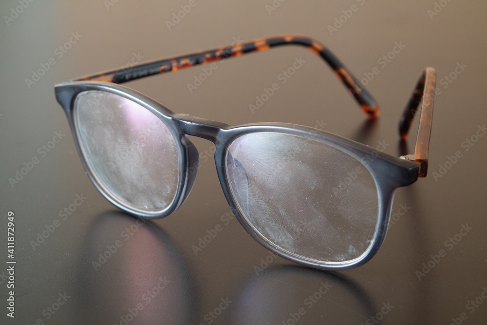 Eyeglasses with fingerprints over the lenses, smudged finger marks ...