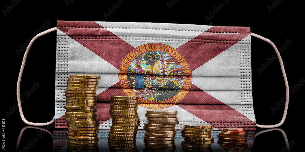 Medical mask with the flag of Florida behind some shrinking stacks of ...