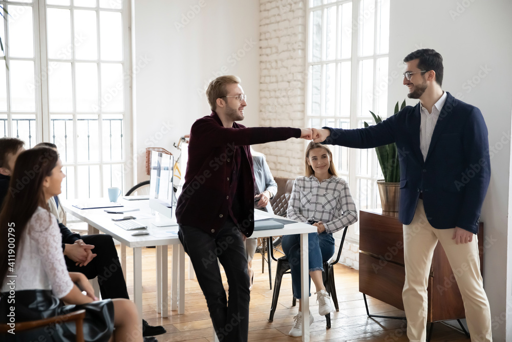 Happy employee congratulating colleague on work achievement or ...