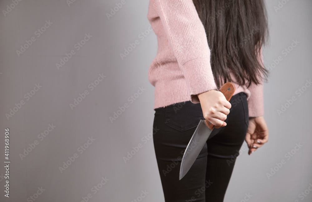 woman holding knife in back Stock 写真 | Adobe Stock