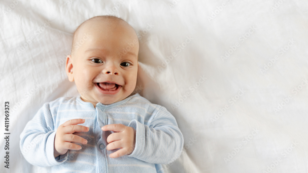 Adorable baby boy in white bedroom. Newborn child relaxing in bed ...