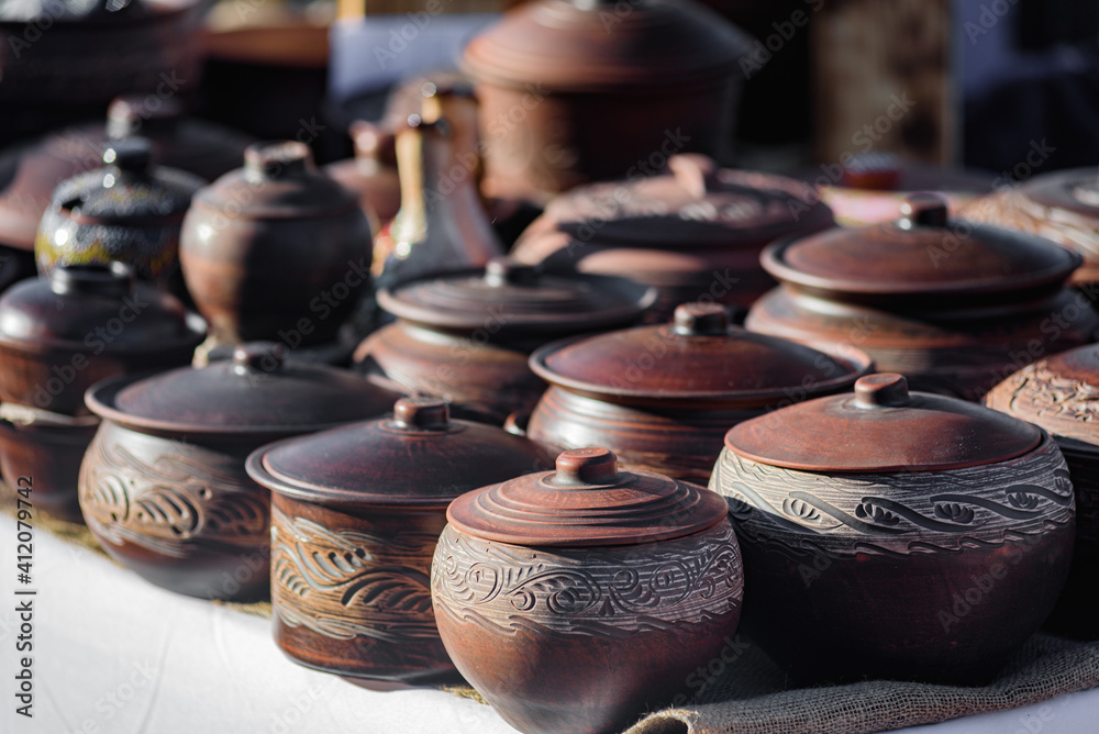 Different traditional Ukrainian pottery pots with ornament in souvenir ...