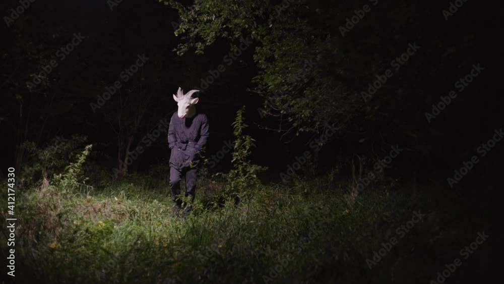 Scary, masked stranger waiting in the dark. Eerie, horror scene with a ...