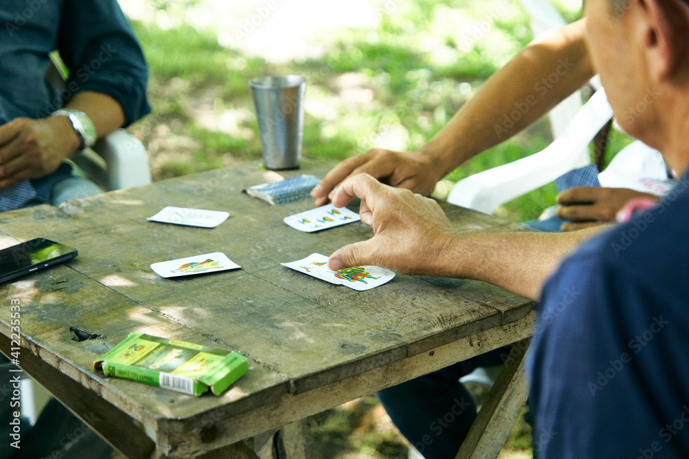 Personas Latinoamericanas jugando a las cartas de truco al aire libre ...