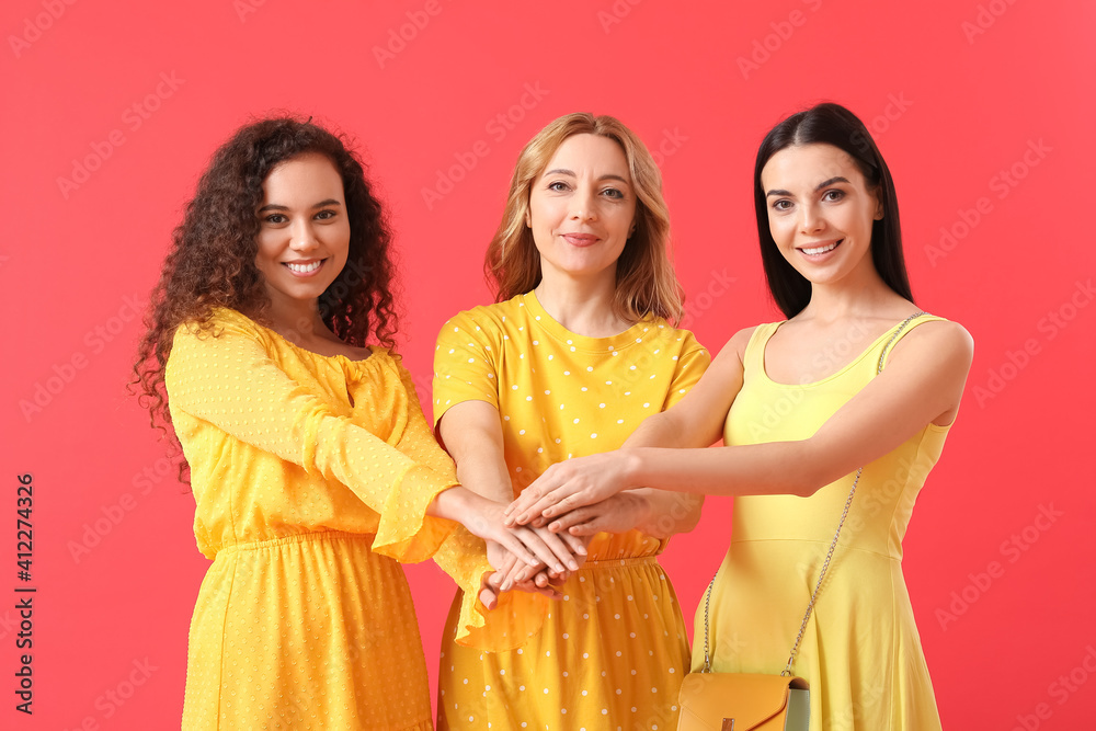 Beautiful women putting hands together on color background. Unity ...