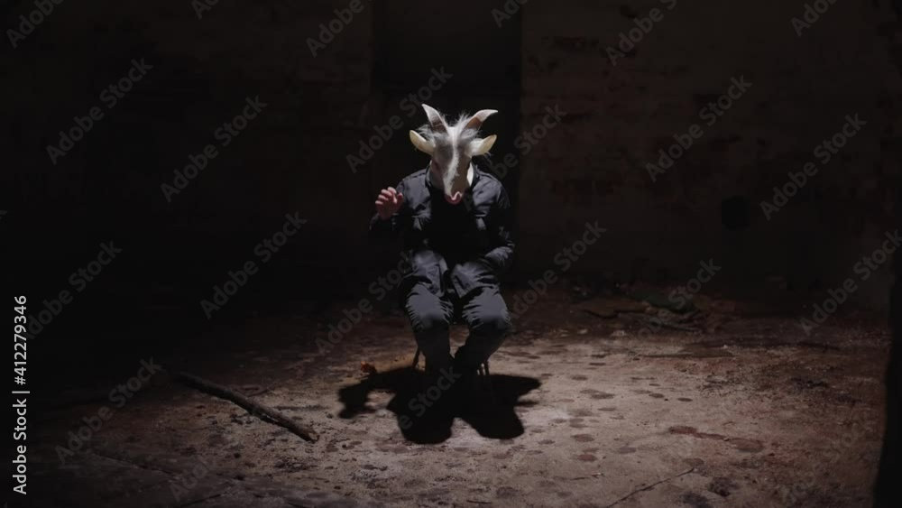 Vidéo Stock Scary masked man waving hand. Crazy maniac in a dark room ...