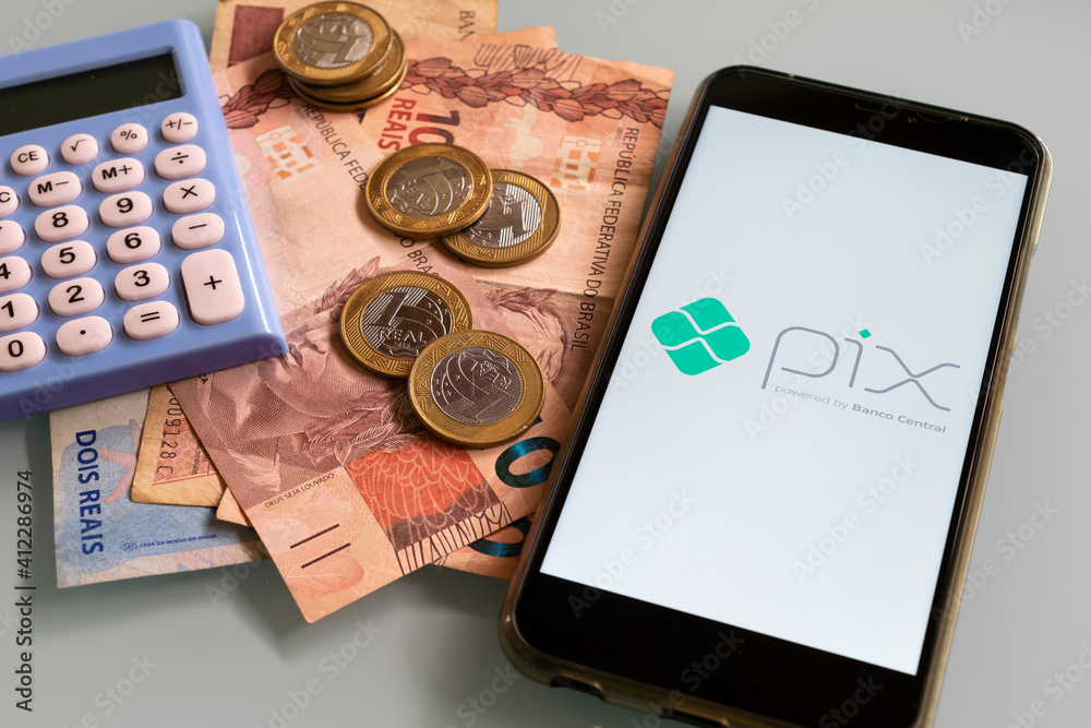 smartphone with the Pix app, on the table with calculator, banknotes ...