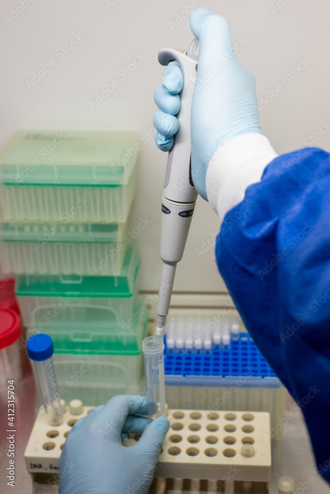 Female scientist using a pipette in a DNA laboratory Stock Photo ...