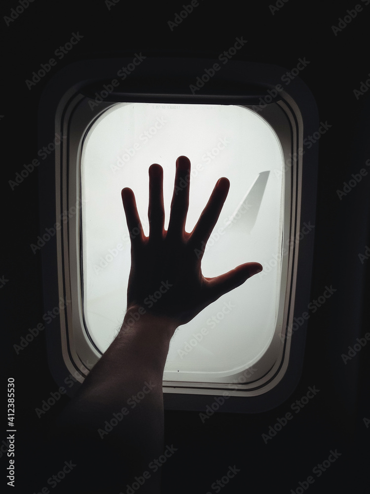 Hand against the window of a plane captured with mobile phone. Stock ...