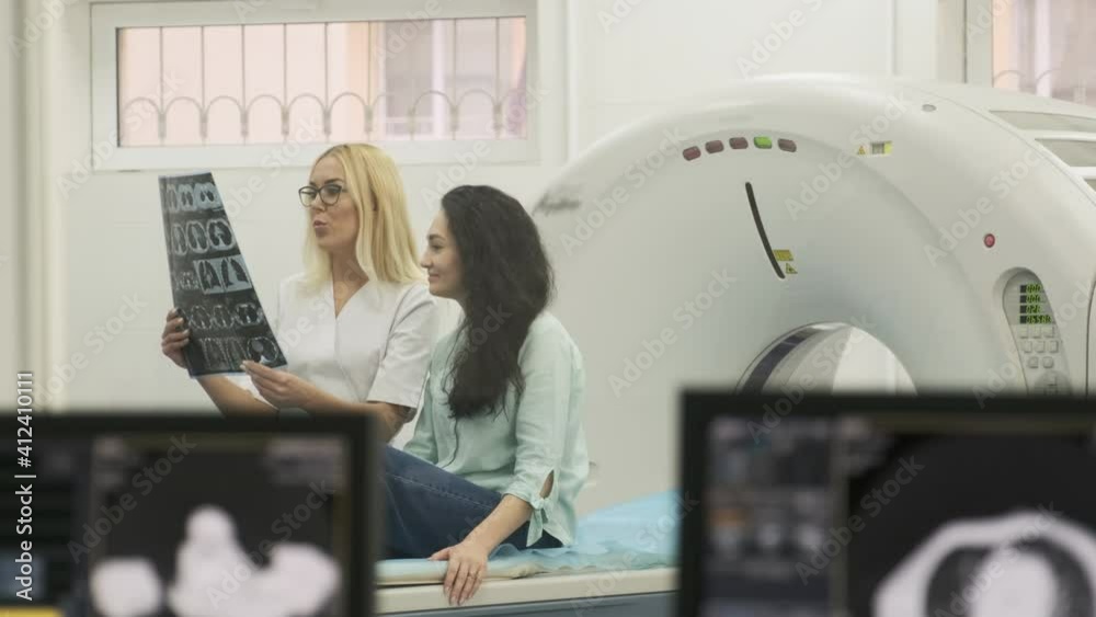 Woman doctor radiologist explains the results of CT scanning for young ...