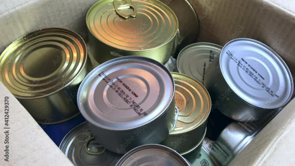 Tin cans with canned goods in a cardboard box - humane social ...
