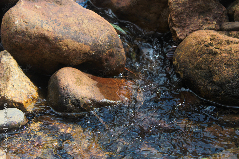 stones in the shallow water. Rock in the lake. Flowing clear water ...