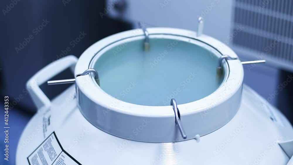 Scientist opens a Cryogenic container with medical reproductive samples ...