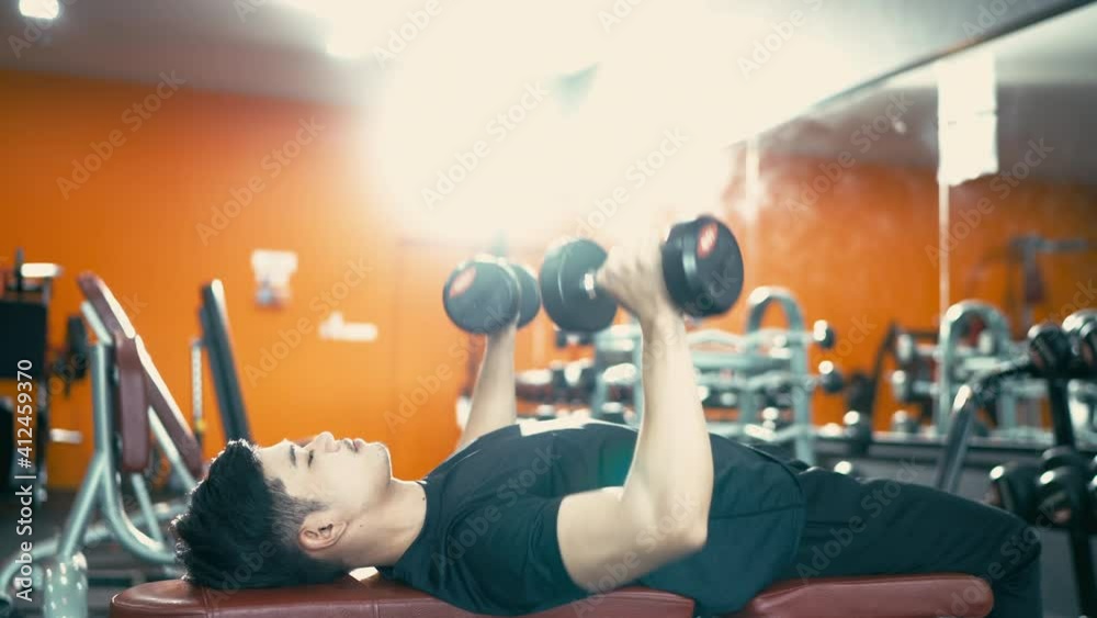 Vidéo Stock strong muscular male bodybuilder trains the triceps, chest ...