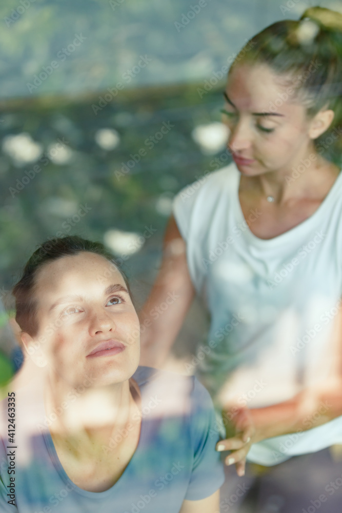 Good shape female Yoga master helps the new goga primary student to ...