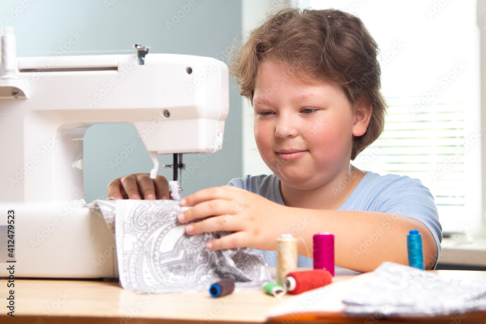 Boy using sewing machine at home to make crafts Stock Photo | Adobe Stock