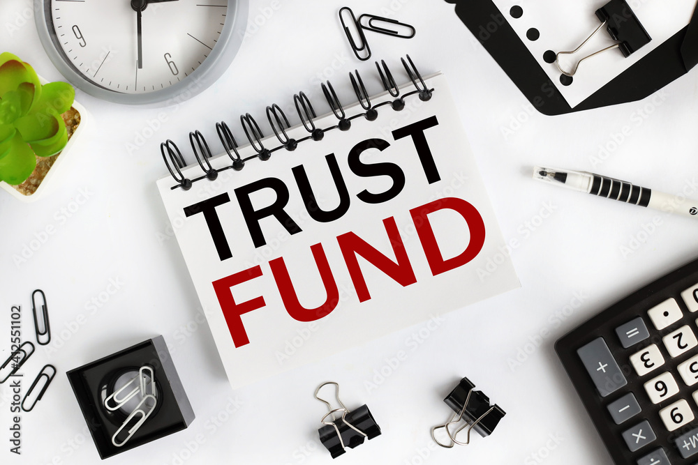 TRUST FUND. text on white notepad paper on light background near ...