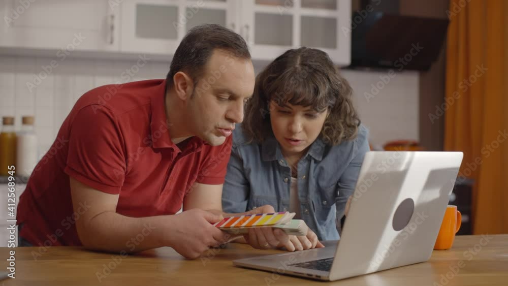 Young couple choosing colors from the Pantone color guide palette.The ...