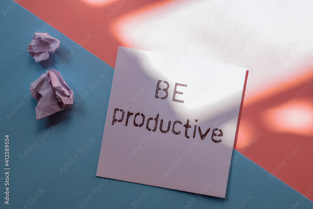 Be productive motivational message in white note paper laid on pastel ...