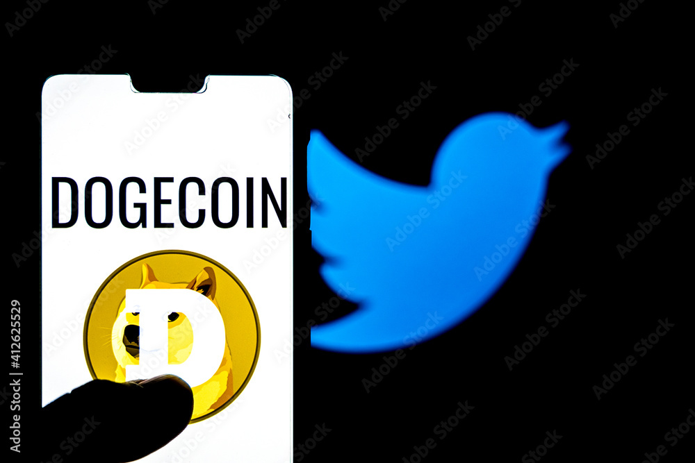 Dogecoin logo on a smartphone aganist twitter logo in the background ...