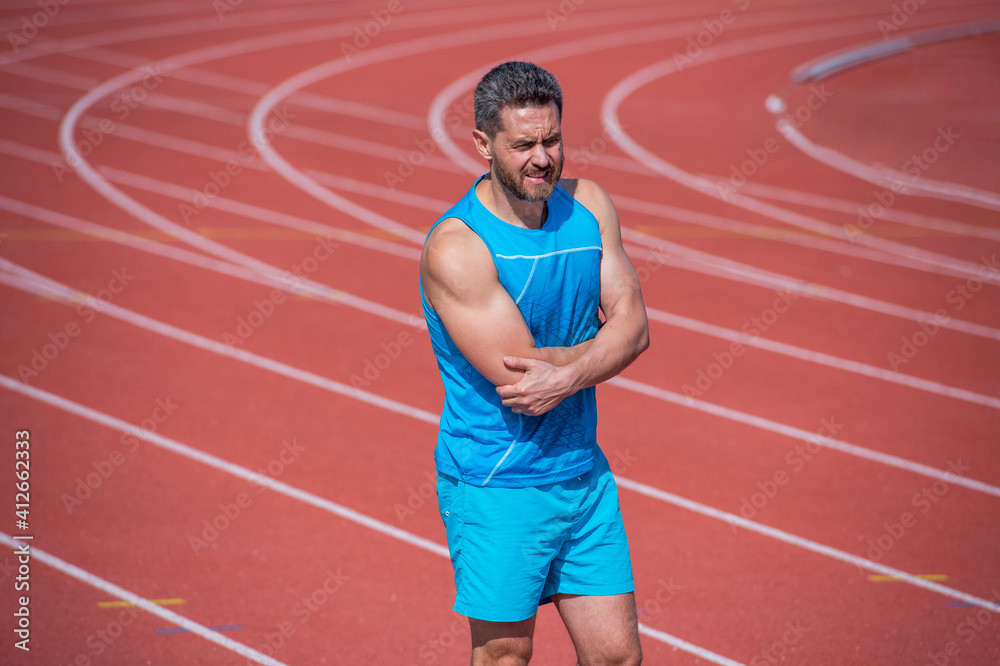 man has injury after exercise on stadium. fitness gym outdoor. muscular ...