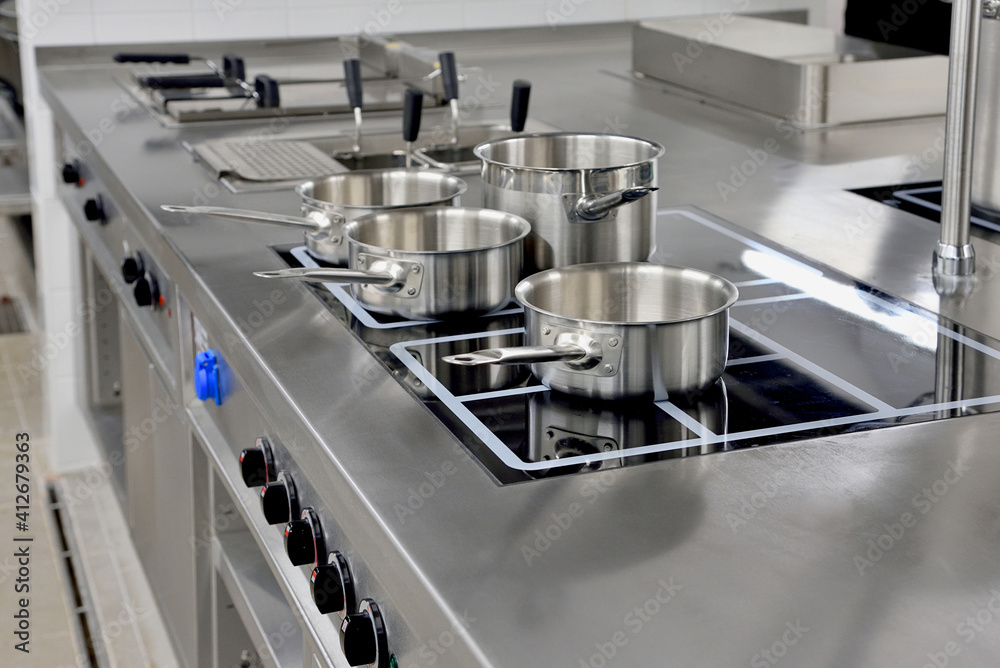 Stainless steel pots built on the stove in the restaurant kitchen foto ...