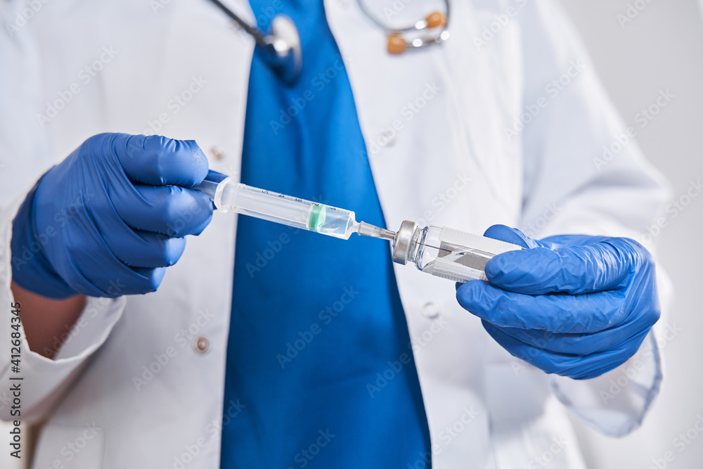 Doctor holding an injection syringe and vaccine Stock Photo | Adobe Stock