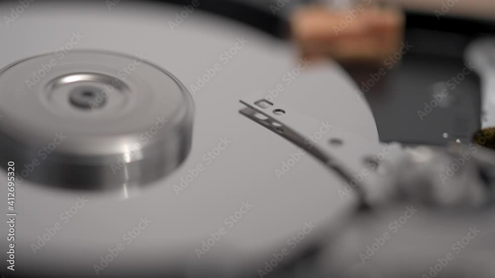 4k Close up video of the read and write head of a hard drive while it ...