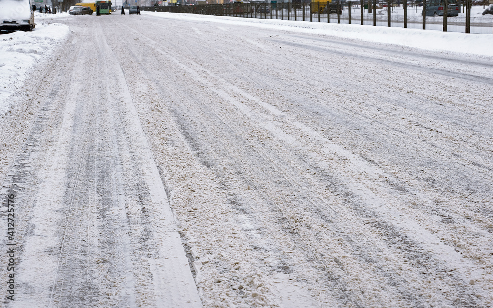 Dirty snow slush, salt and melting reagents on city road with traces ...