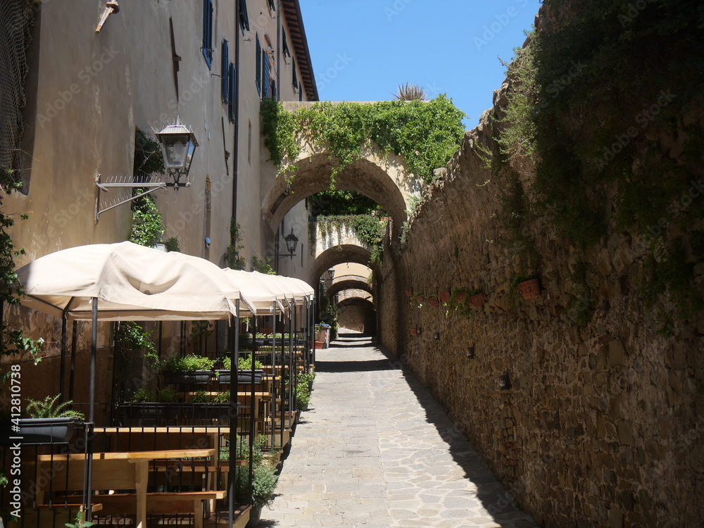 Typical medieval street of Castiglione della Pescaia, squeezed between ...
