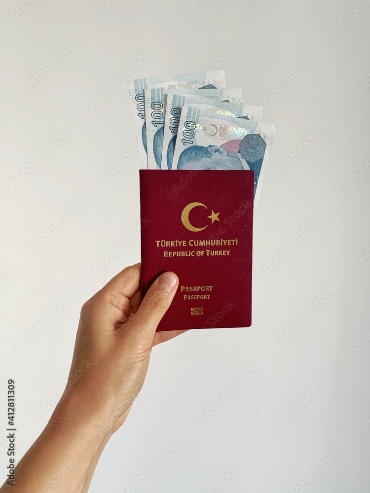 Hand holding Turkish passport with 1000 liras banknotes inside the ...