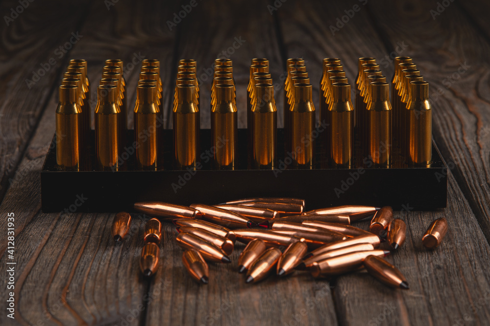 Heavy hunting bullets and prepared casings on a wooden background, ammo ...