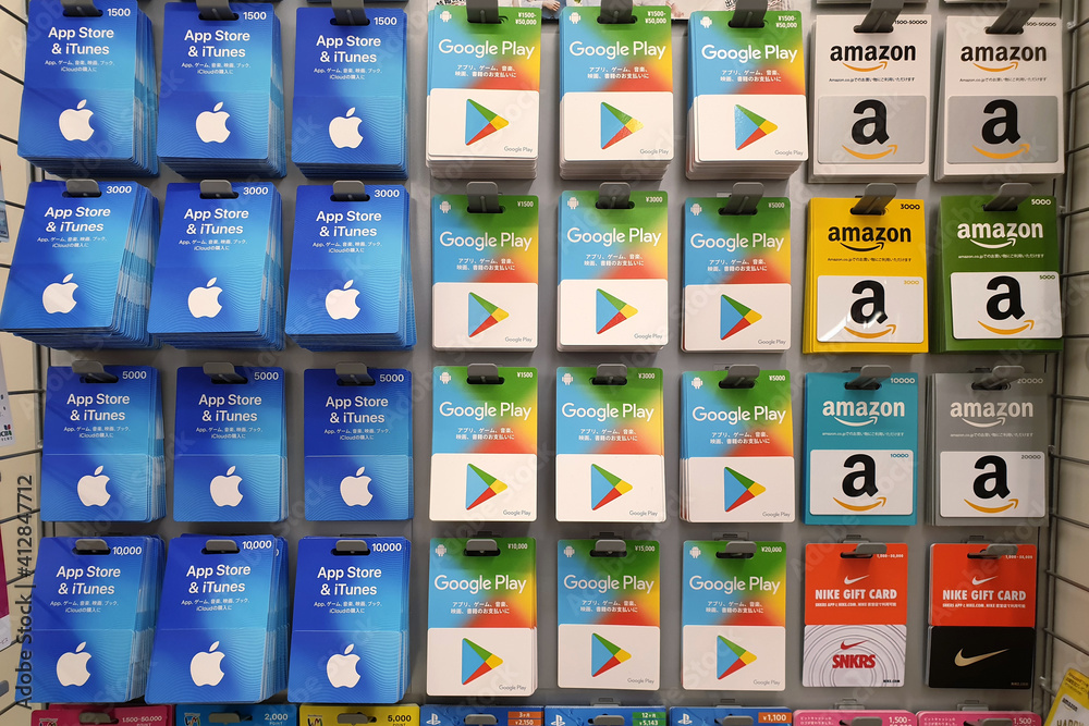 Apple App Store and Google play gift cards on store shelf. A gift card ...