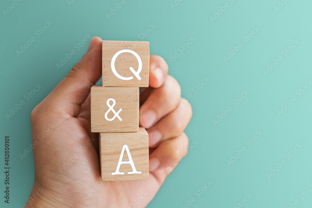 Q and A alphabet on wooden cube in hand hold with background. Question ...