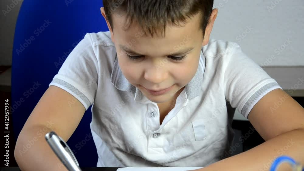 A child of primary school age do homework. The boy does his homework at ...