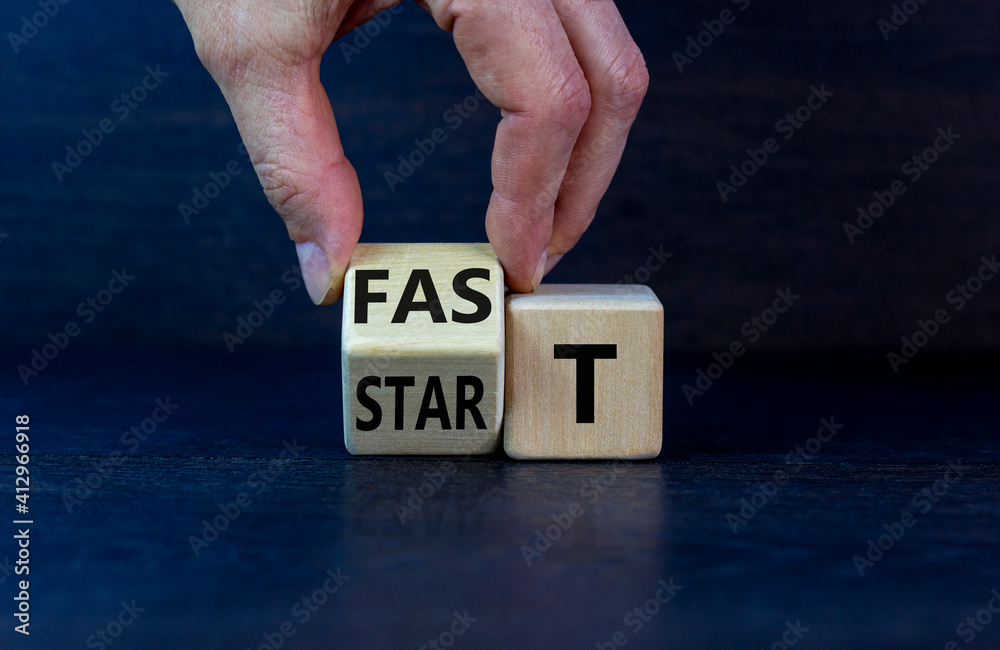 Time to fast start symbol. Businessman turns a wooden cube with words ...
