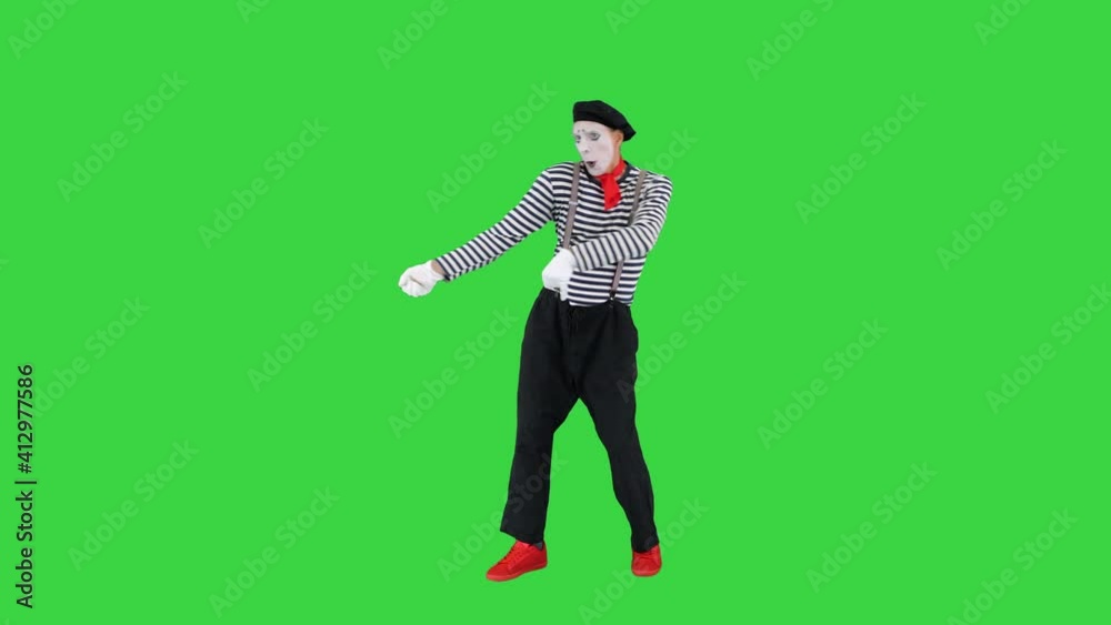 Male mime artist performing pulling virtual rope on a Green Screen ...