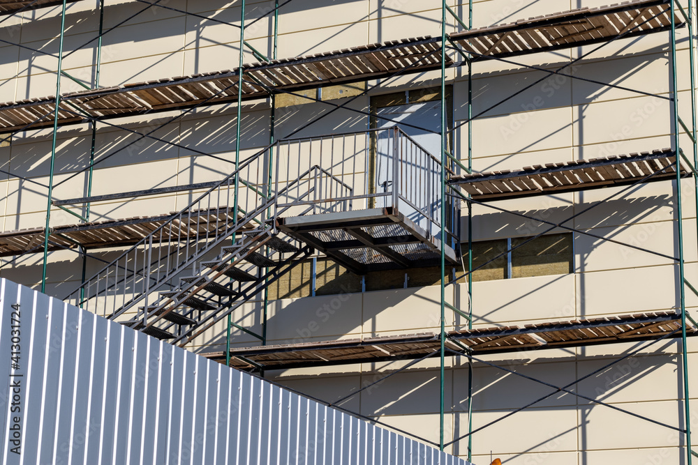 Foto de scaffolding on a construction site. Cladding of building with ...