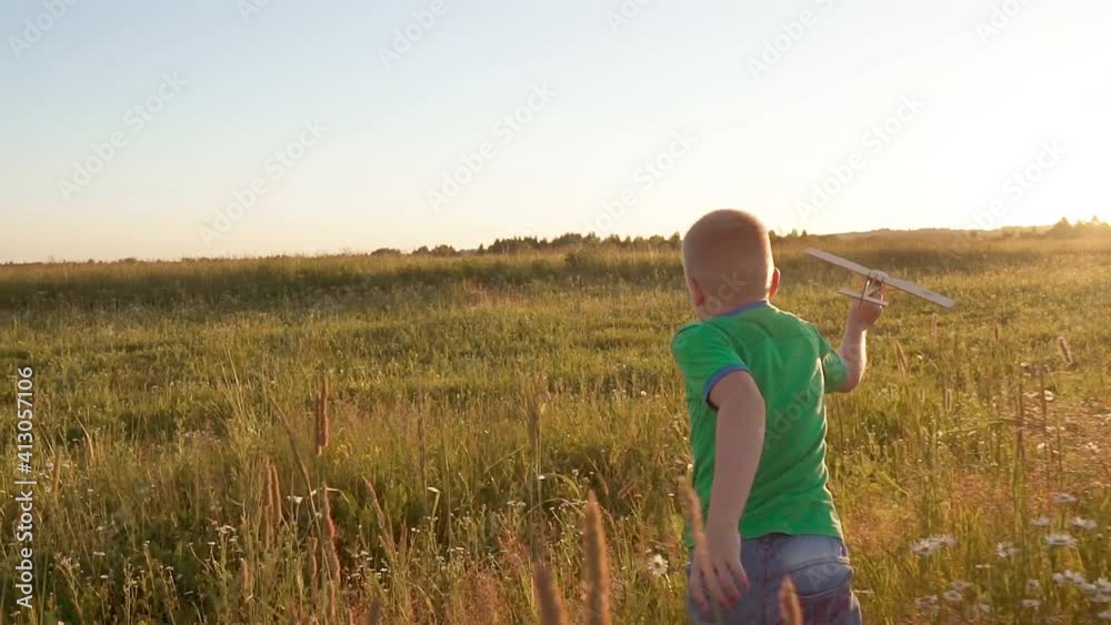 Vidéo Stock Happy child running with a toy airplane on a sunset ...