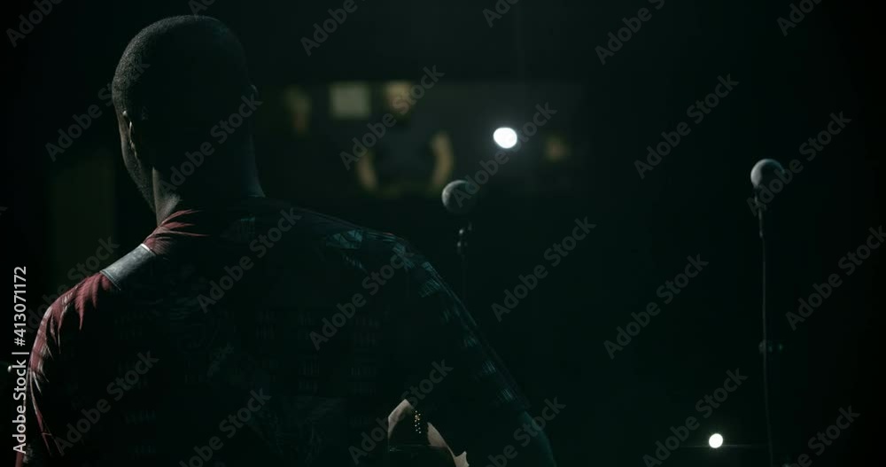 Black music man standing back giving performance. Isolated rear view of ...