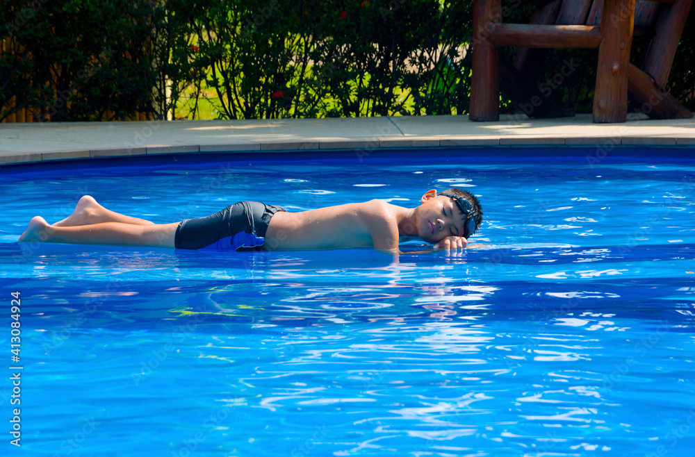 Full Length Of Shirtless Boy Lying On Swimming Pool Stock Photo | Adobe ...