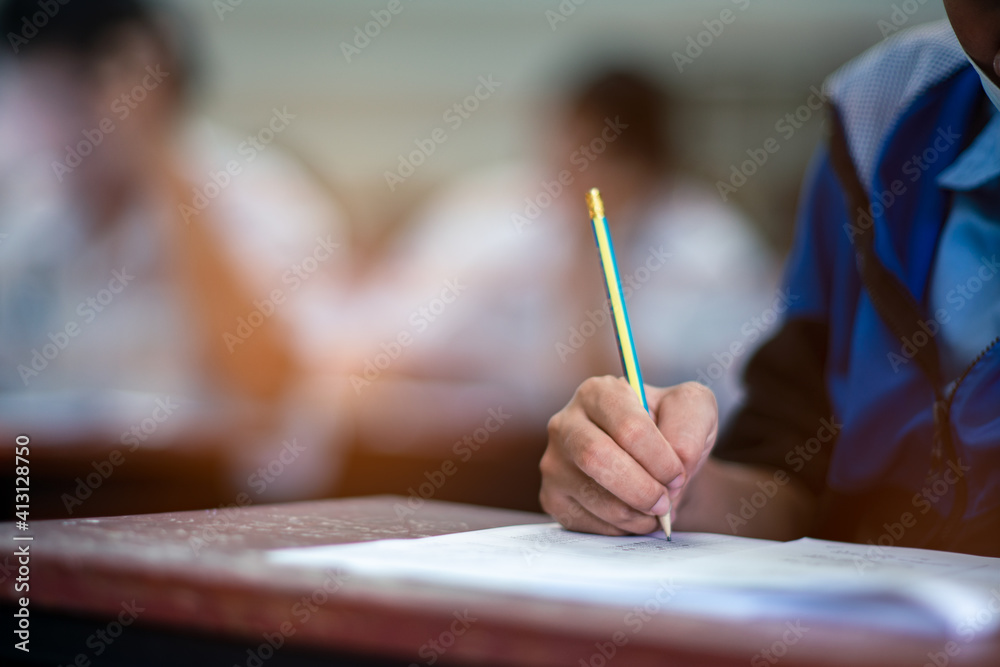 Students writing and reading exam answer sheets exercises in classroom ...