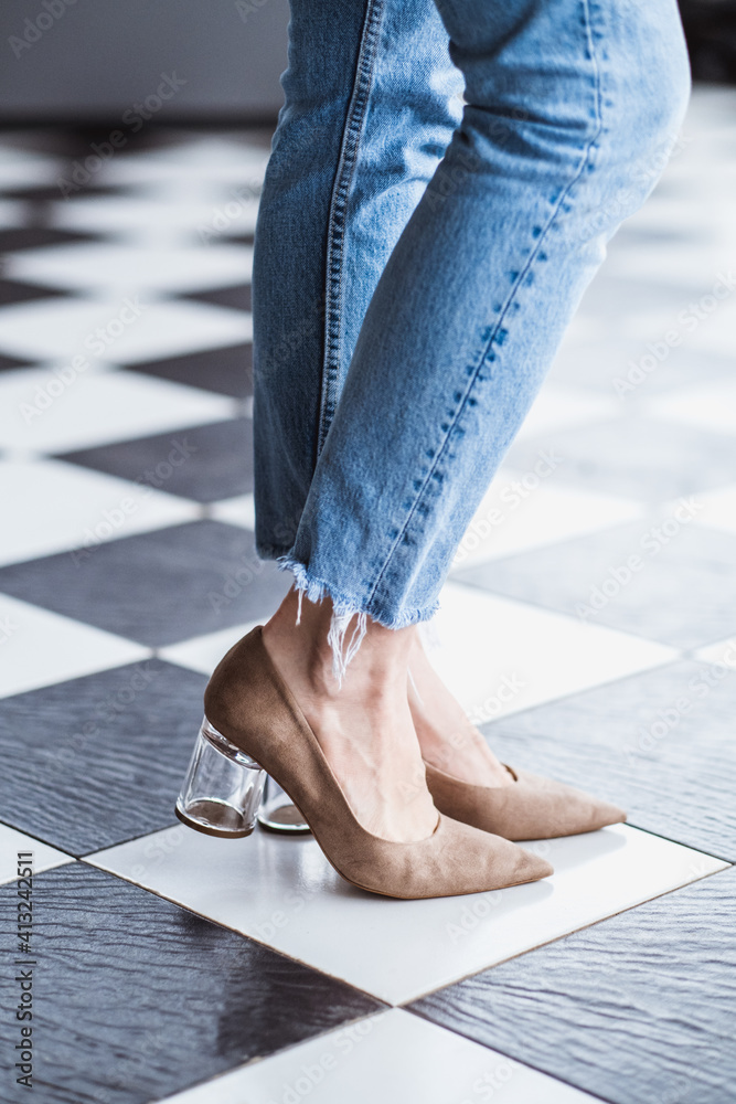 Beautiful slim and slender female legs in jeans in beige high heels ...
