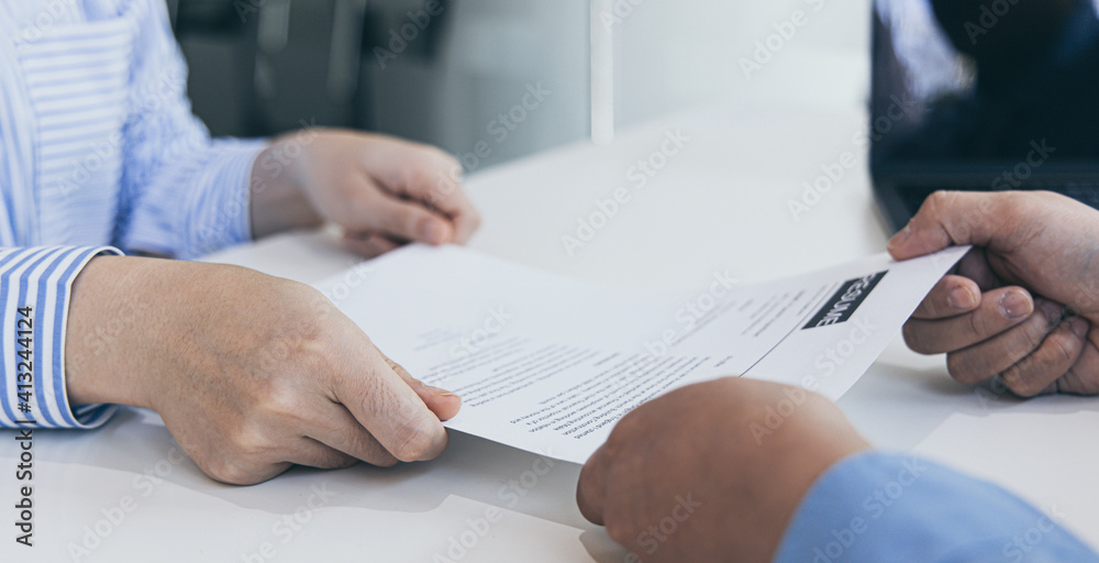 Applicants submitting a resume to the staff to apply for a job ...