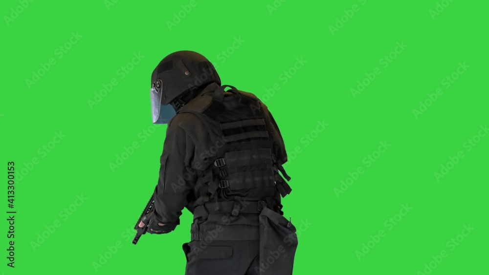 Masked Armed SWAT Police Officer Walking and aiming with rifle on a ...