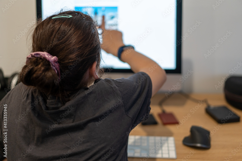 child on computer from behind, pointing at the screen, learning and ...