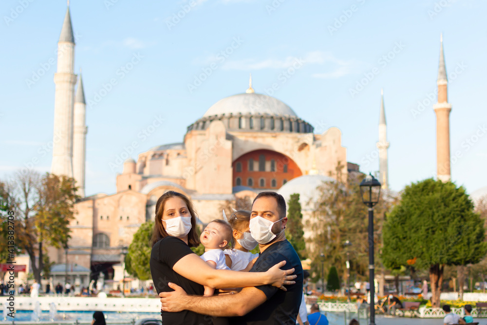 Portrait of happy tourist family in mask in front of Hagia Sophia ...